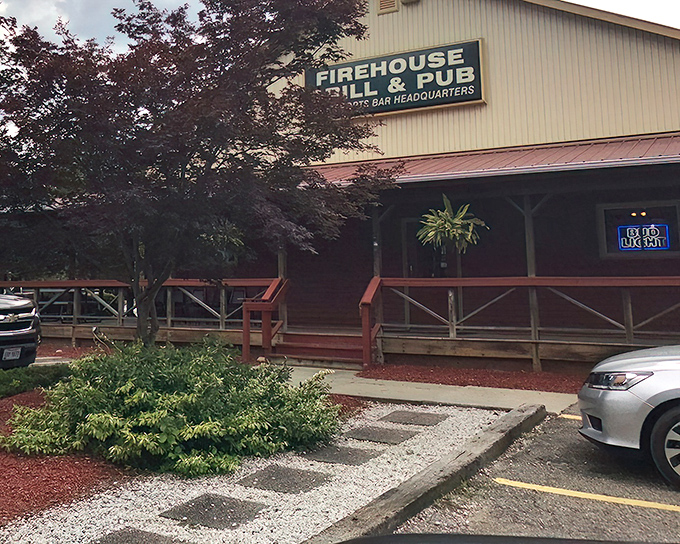 The welcoming exterior of Rootstown Firehouse Grille & Pub, where wooden porch railings and hanging plants invite you to discover culinary treasures inside.