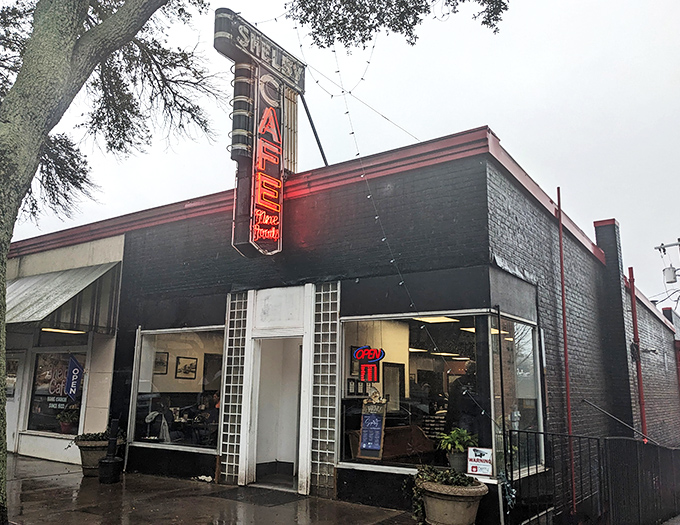 That vintage neon sign beckons hungry travelers like a lighthouse for comfort food enthusiasts. Even in the rain, it promises warmth inside.