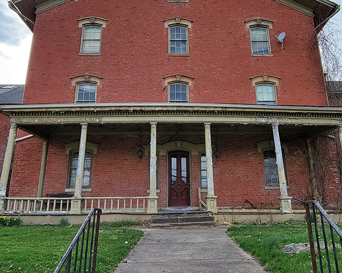 Red brick and haunting symmetry. The front façade's weathered columns and worn steps have welcomed the desperate and downtrodden for over a century.