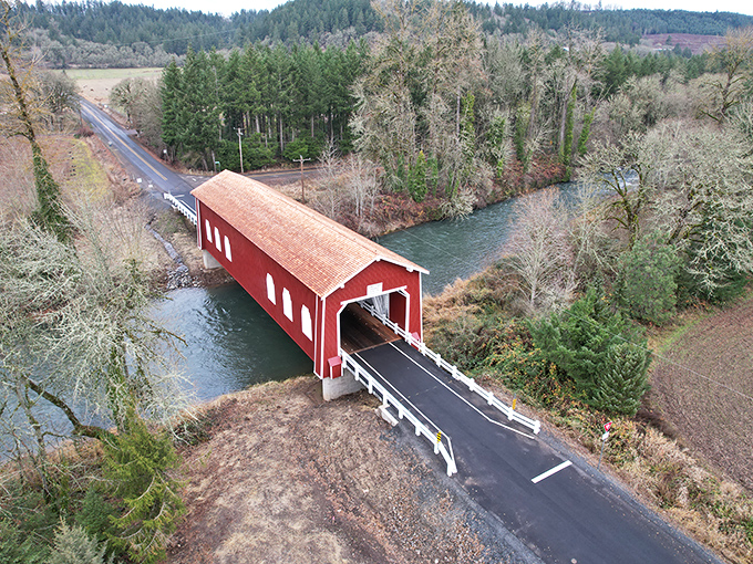 Like finding a cardinal in the forest, Shimanek Bridge's vibrant red exterior stands out dramatically against Oregon's lush landscape, spanning Thomas Creek with timeless grace.