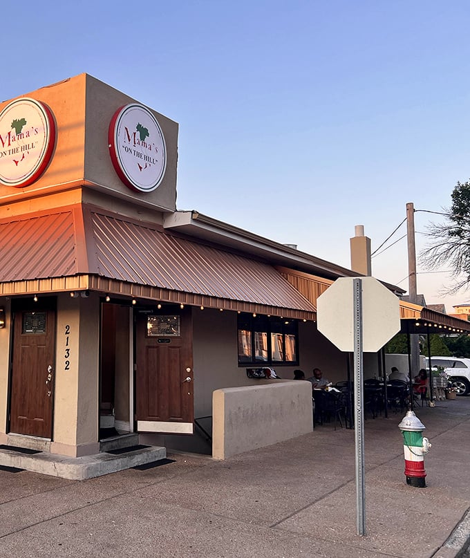 Bathed in golden sunset light, Mama's welcoming fa&ccedil;ade promises the authentic flavors of Italy with its distinctive signage and cozy outdoor seating area.