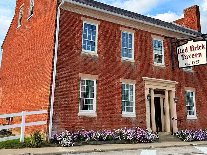 The Red Brick Tavern stands proudly since 1837, its vibrant facade and colorful flower boxes a welcoming sight that's been greeting travelers for nearly two centuries. 