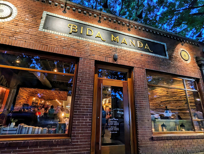 The brick facade of Bida Manda glows with warm invitation at twilight, like a culinary lighthouse beckoning hungry souls through downtown Raleigh.