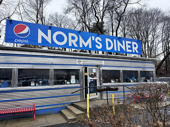 The iconic blue and silver exterior of Norm's Diner stands like a time machine on wheels, permanently parked in Groton and ready to transport you to breakfast nirvana.