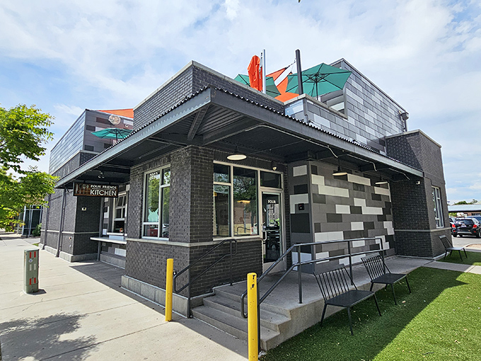 The modern brick exterior of Four Friends Kitchen stands like a culinary lighthouse in Denver's Stapleton neighborhood, complete with a rooftop patio that beckons brunch enthusiasts.