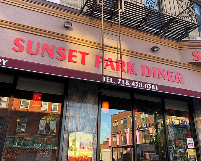 The iconic red lettering of Sunset Park Diner beckons like an old friend, promising comfort food that never goes out of style.
