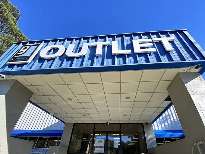 The blue "OUTLET" sign beckons like a siren call to treasure hunters. Adventure awaits beyond those sliding doors!