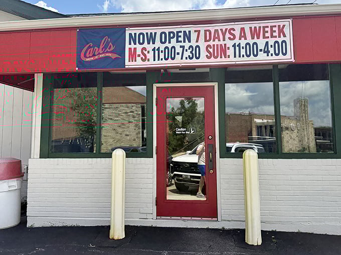 The unassuming exterior of Carl's Drive-In stands like a time capsule on Manchester Road, its red trim promising nostalgic delights within.