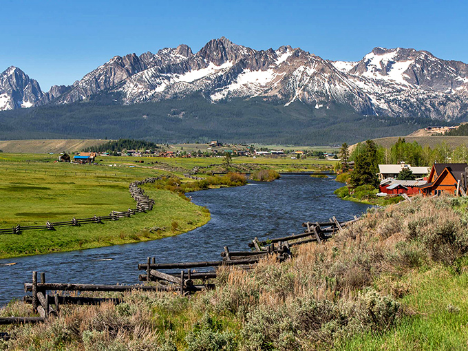 Nature's perfect postcard: The Sawtooth Mountains rise like a fortress wall behind Stanley, where the Salmon River curves through meadows like it's showing off.