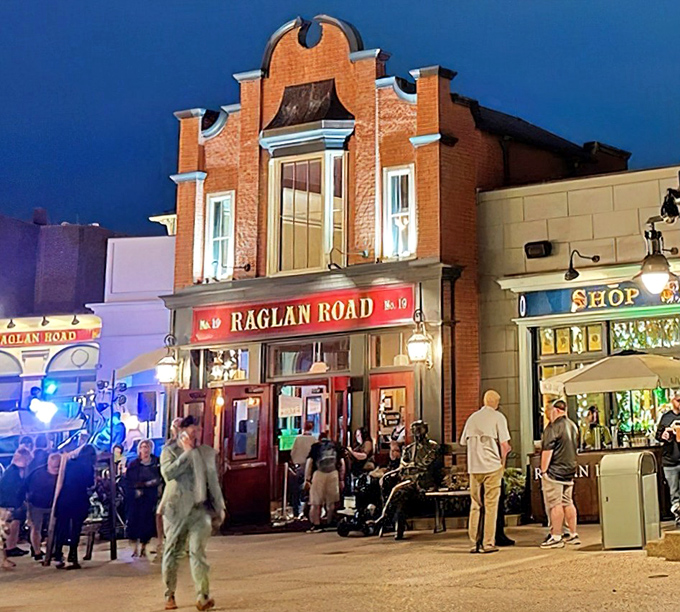 By night, the pub's warm glow beckons visitors like a lighthouse for the thirsty, transforming from daytime charm to evening magic.