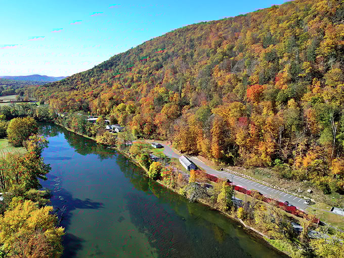 The Housatonic River cuts through Kent's autumn splendor like nature's own masterpiece, complete with a red train that seems to say, "I'm just showing off now."