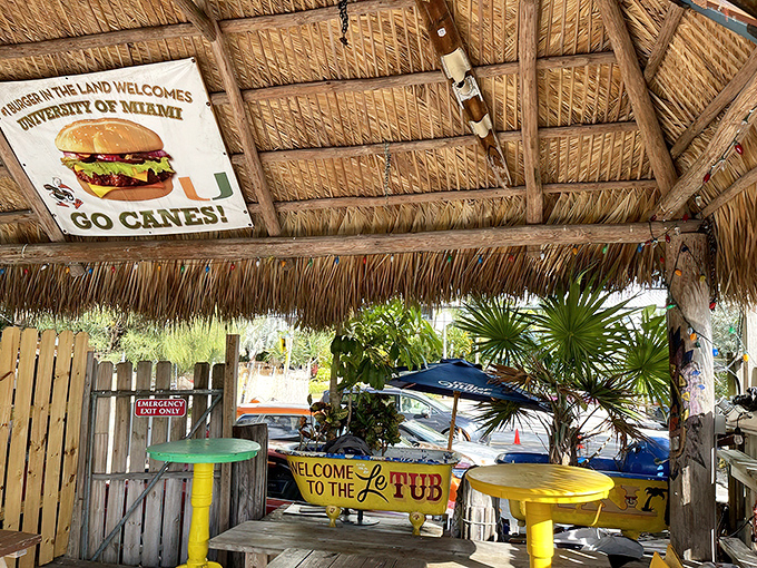 The thatched tiki roof shelters diners while a University of Miami burger sign reminds you that even college sports royalty appreciates Le Tub's legendary patties.