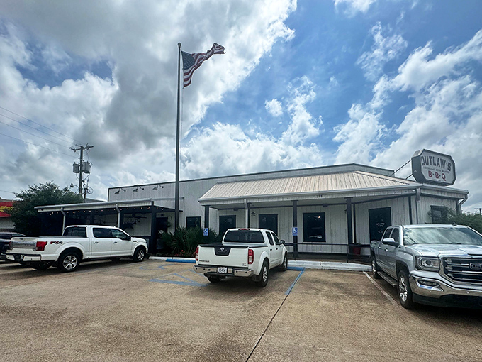 The unassuming white exterior of Outlaws BBQ stands like a smoke-scented beacon of hope for hungry travelers in Alexandria.