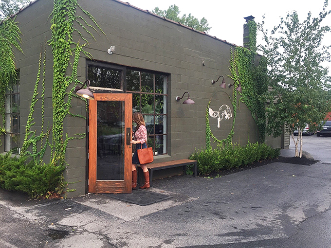 Another angle of the charming exterior shows the cafe's signature fox logo peeking through seasonal ivy. A wooden bench invites you to pause before entering this Columbus treasure.