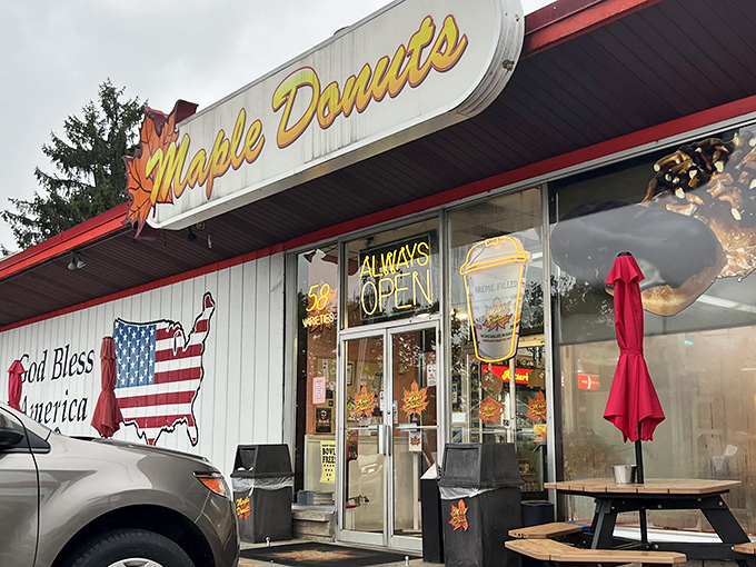 The iconic Maple Donuts sign glows like a beacon of sugary hope against Pennsylvania's sky. A patriotic touch with that "God Bless America" mural.