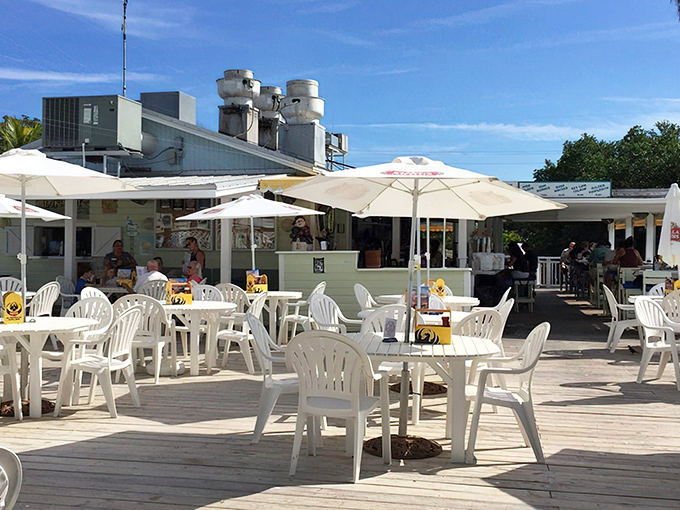 White plastic chairs never looked so inviting. Under cheerful yellow umbrellas, this casual outdoor seating area promises cold drinks and warm memories.