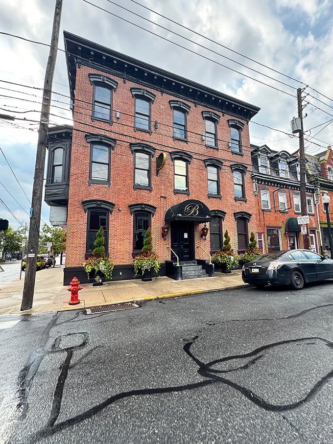 The stately Victorian brick facade of The Belvedere Inn stands proudly on Lancaster's streets, its elegant black awning and spiral topiaries promising culinary magic within.