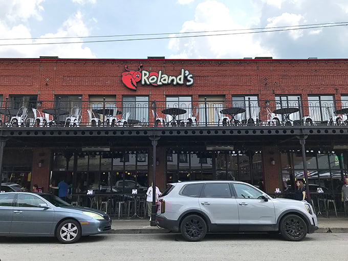 Roland's brick exterior with its cheerful lobster logo promises seafood salvation in Pittsburgh's vibrant Strip District.