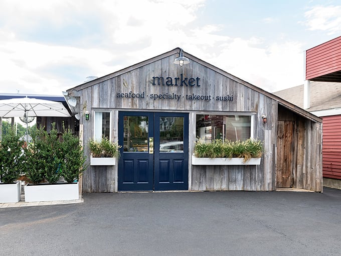 The weathered gray shingles and navy blue doors of Rowayton's market aren't just charming—they're a promise that seafood authenticity awaits inside.