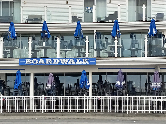 The iconic blue-and-white facade of Boardwalk Cafe & Pub stands proudly along Hampton Beach, those blue umbrellas practically waving you in like old friends.