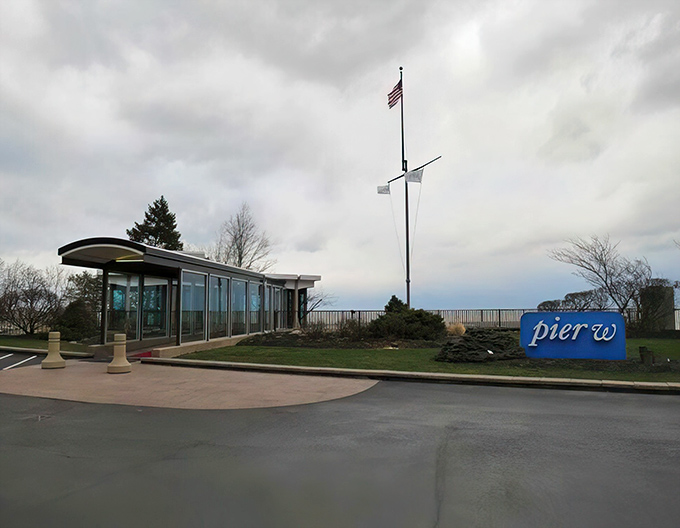 Pier W's entrance welcomes you like a maritime embrace, with vibrant flowers standing guard beside that iconic blue sign. Lake Erie's best-dressed restaurant awaits.