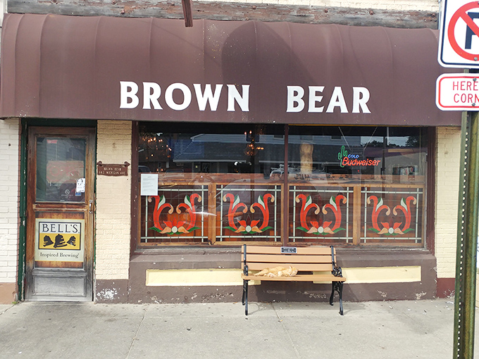 The unassuming storefront of Brown Bear in Shelby, complete with classic brown awning and sidewalk bench &ndash; Michigan's burger paradise hiding in plain sight.
