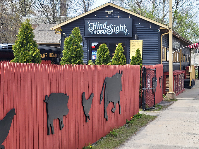 The red fence with farm animal cutouts is your first clue &ndash; this isn't just dinner, it's a pilgrimage to smoke-infused paradise.