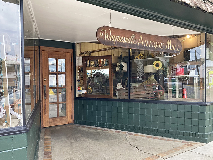 The charming green facade of Waynesville Antique Mall beckons treasure hunters with its vintage wooden door and classic small-town appeal.