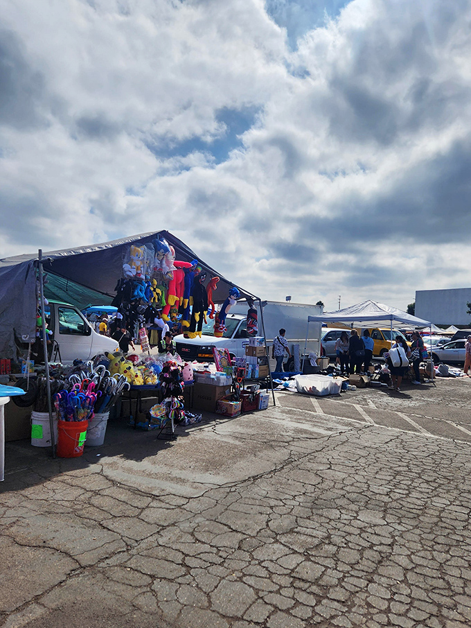 The iconic drive-in movie screen looms over a colorful sea of vendors, where morning bargain hunters navigate aisles of potential treasures.