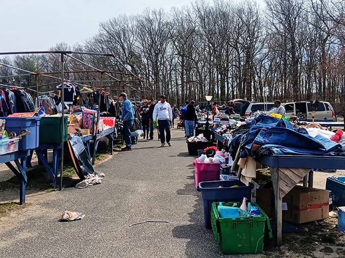 A vendor carefully arranges his merchandise as shoppers begin their Sunday morning treasure hunt. In this outdoor bazaar, patience rewards the persistent.