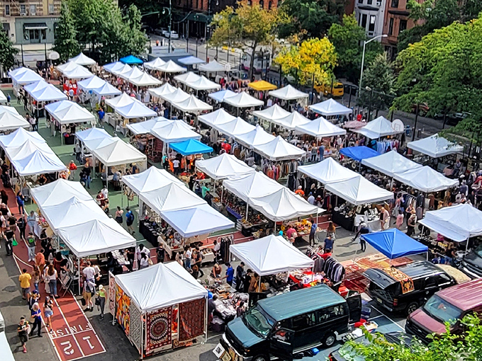 The aerial view reveals Grand Bazaar NYC's impressive scale—a sea of white tents where treasure hunters navigate the urban equivalent of Ali Baba's cave.