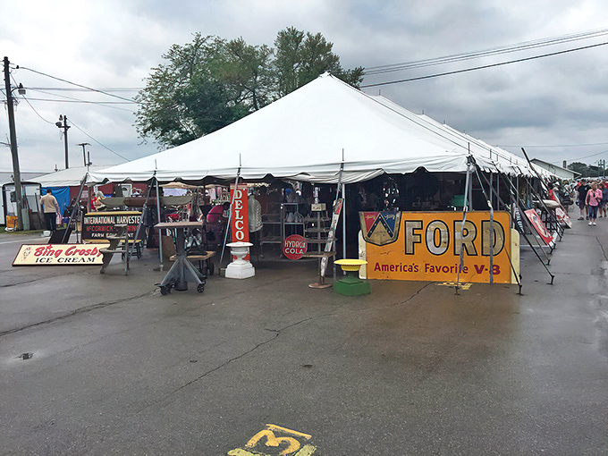 White tents stretch across the fairgrounds, housing treasures like this vintage Ford sign – the starting line for your antiquing marathon.