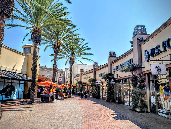 Palm trees line the brick walkways like nature's own VIP escorts, guiding shoppers through this retail fortress where bargains await around every corner.