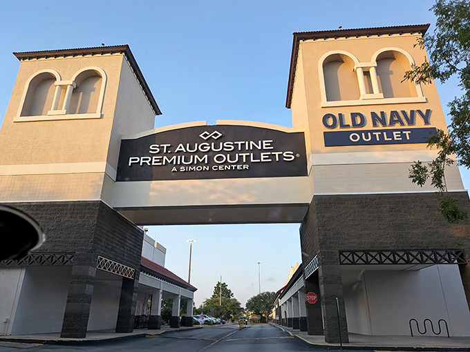 The iconic entrance to St. Augustine Premium Outlets stands like a retail Colosseum, promising treasures within those Spanish-inspired towers. Blue skies above suggest the shopping gods are smiling on your credit card today.