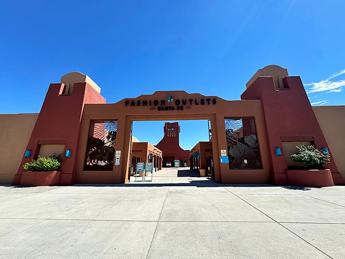 The iconic terracotta entrance to Fashion Outlets of Santa Fe stands like a Southwest welcome committee, promising retail therapy under that famous New Mexico blue sky.