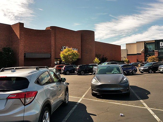 The brick fortress of JCPenney stands guard at Washington Square, where shopping dreams and parking nightmares coexist in retail harmony.