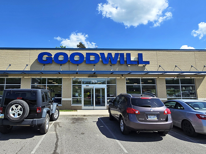 The blue Goodwill sign beckons like a thrifty lighthouse, guiding bargain hunters safely to shore. No wallet is too small for this treasure trove.