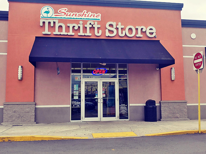 The coral-colored facade of Sunshine Thrift Store beckons like a beacon of bargain possibilities, promising treasures behind those glass doors.