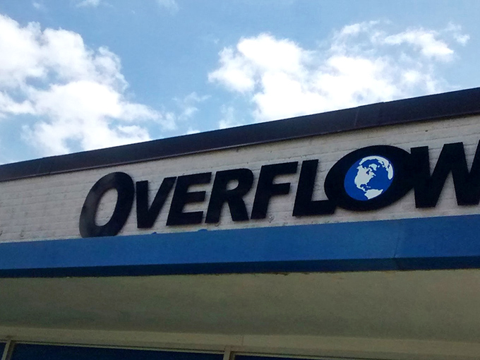 Overflow's iconic sign against the Iowa sky &ndash; where the globe logo hints at the world of possibilities waiting for intrepid treasure hunters within.