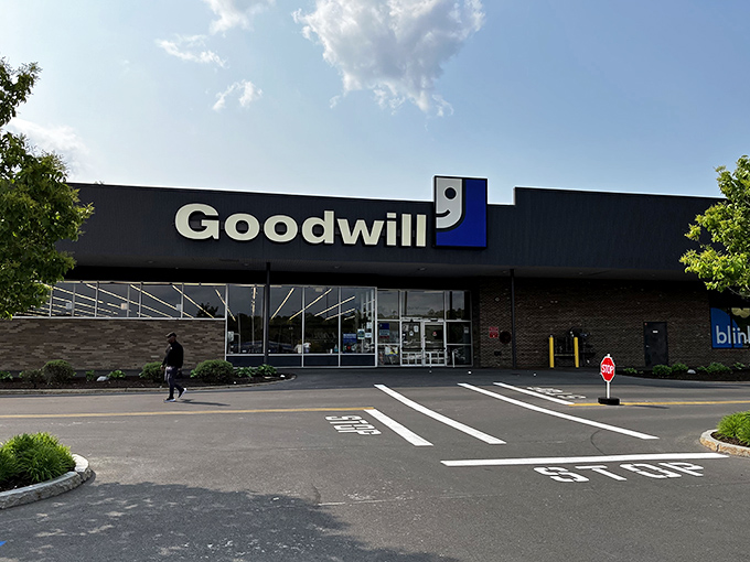 The blue and white Goodwill sign beckons like a lighthouse for bargain hunters, promising treasures within that won't break the bank.
