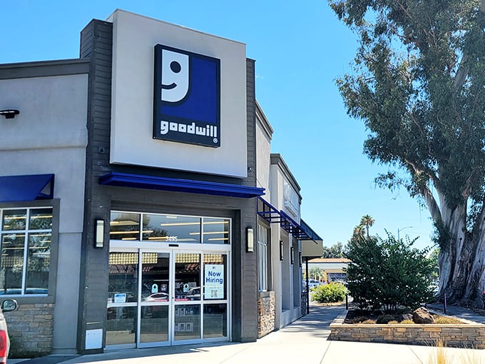 The iconic blue Goodwill sign stands like a beacon of bargain hope against the California sky, promising treasures within those sliding glass doors.