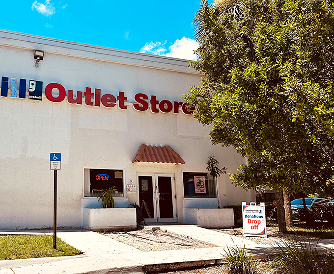 The unassuming facade of bargain paradise! This white building with bold red "Outlet Store" signage promises treasure hunting adventures beyond its humble exterior.