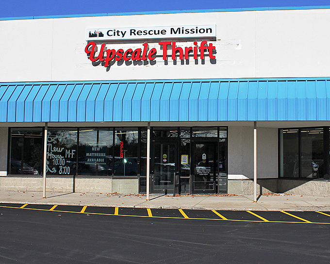 The bright blue awning of City Rescue Mission Uplift Thrift stands out like a beacon for bargain hunters, promising treasures within its unassuming exterior.