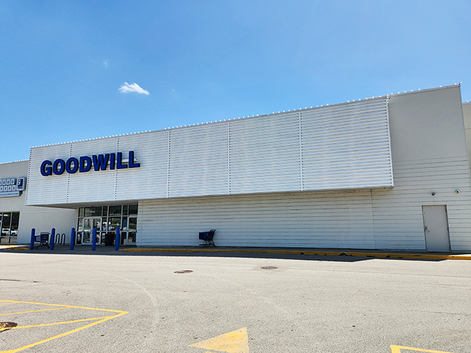 The gleaming white exterior of Omaha's West Center Road Goodwill beckons like a treasure chest waiting to be unlocked. Blue lettering promises adventures in thrifting.
