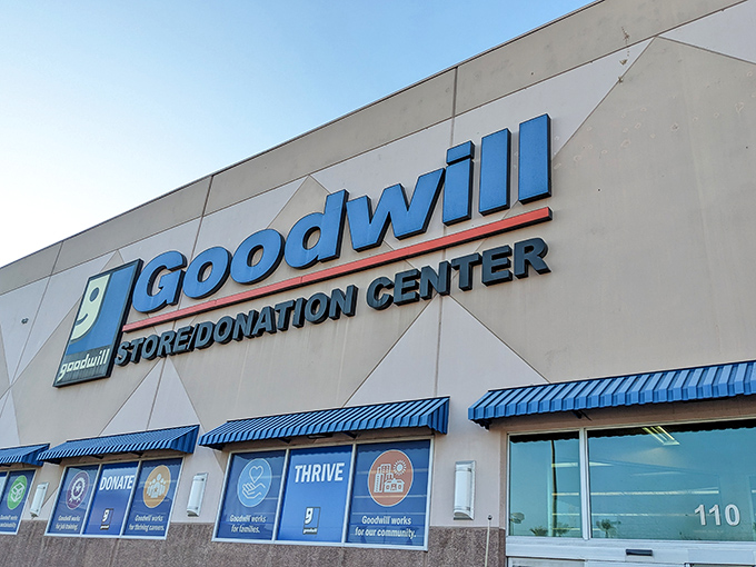 The iconic blue Goodwill sign beckons bargain hunters like a desert oasis promising treasures instead of water.
