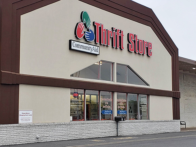 The iconic CommunityAid storefront beckons bargain hunters with its colorful logo, promising treasures inside that would make any thrift enthusiast's heart skip a beat.