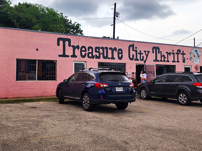 The bubblegum pink exterior of Treasure City Thrift stands out like a flamingo at a penguin convention, complete with their cartoon mascot promising "Spending That Money."