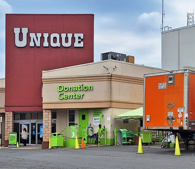 The bold red Unique sign stands like a beacon for bargain hunters, with its bright green donation center ready to transform yesterday's castoffs into tomorrow's treasures.