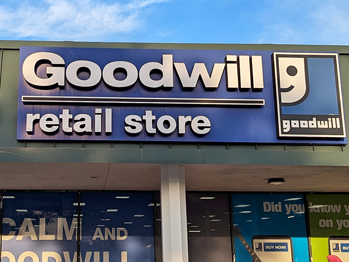 The iconic blue and white Goodwill sign beckons bargain hunters like a retail lighthouse guiding ships to treasure-filled shores.