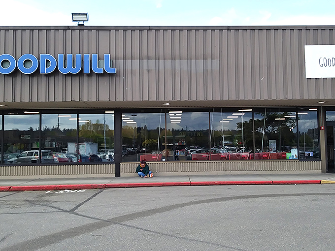 The blue Goodwill sign stands out against the brown exterior like a beacon for bargain hunters, promising treasures waiting to be discovered inside.